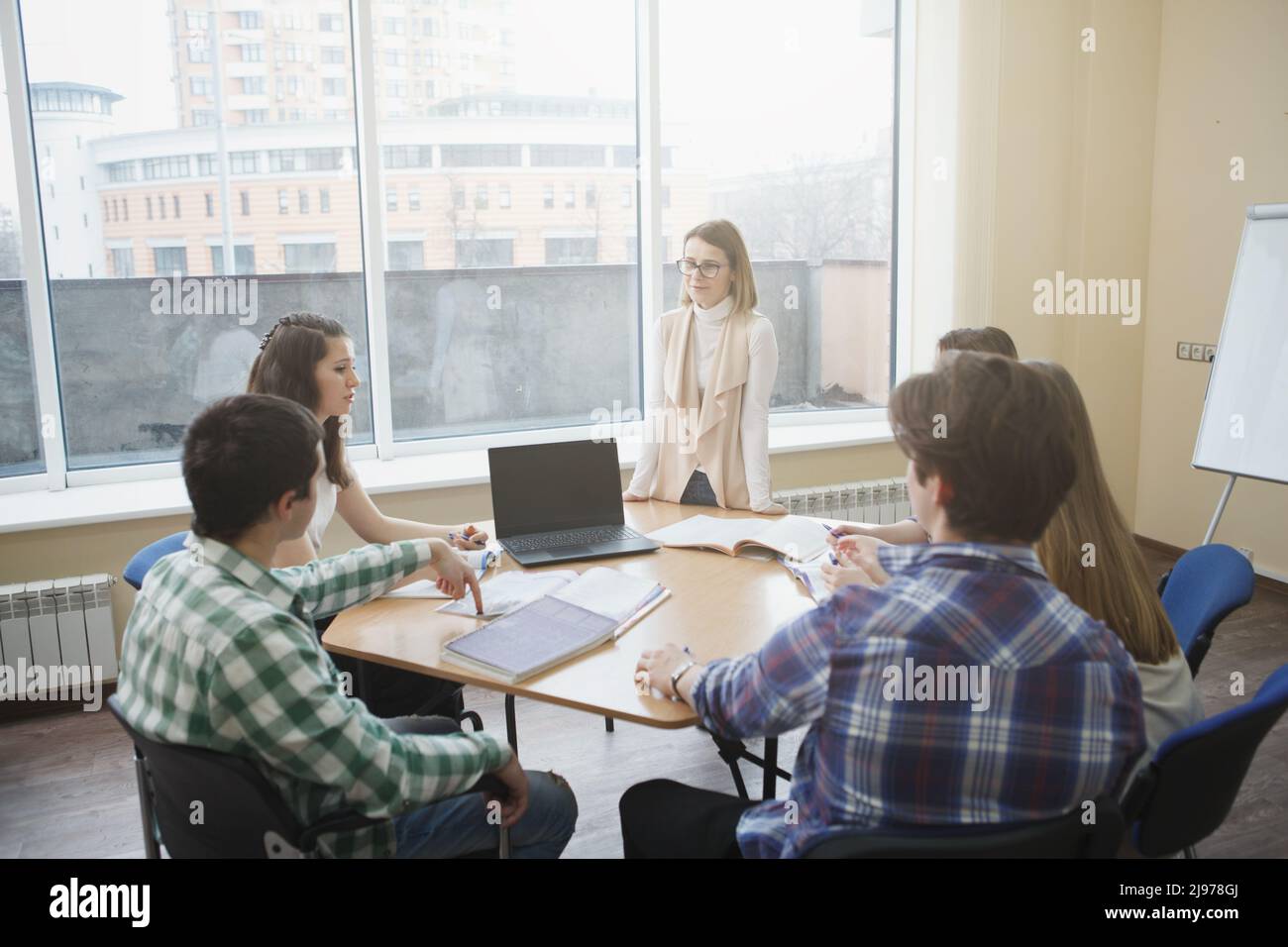 Mature female lecturer having class with her university students, copy ...