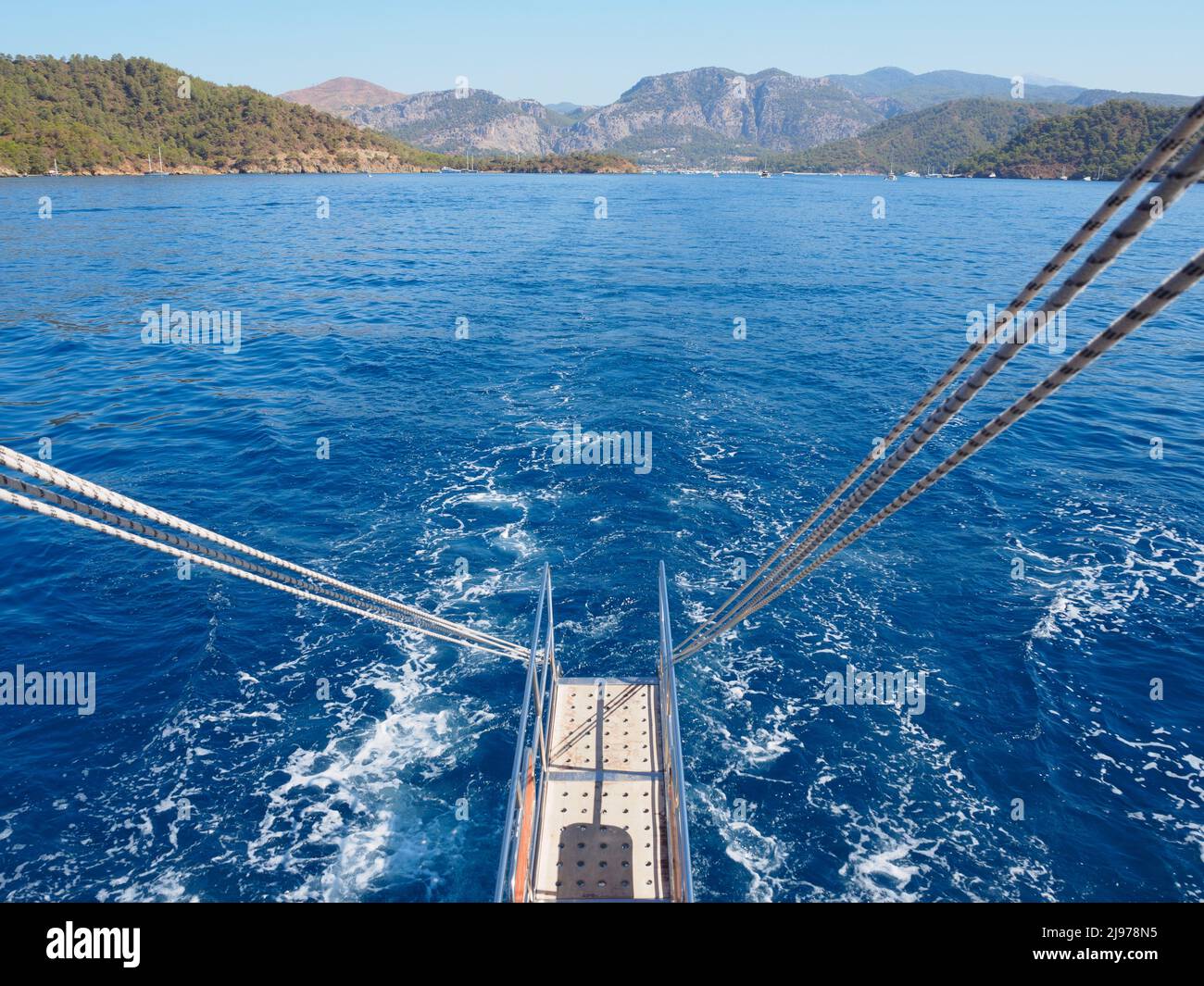 Göcek, seen behind the tour boat sailing to the sea. Muğla, Turkey ...