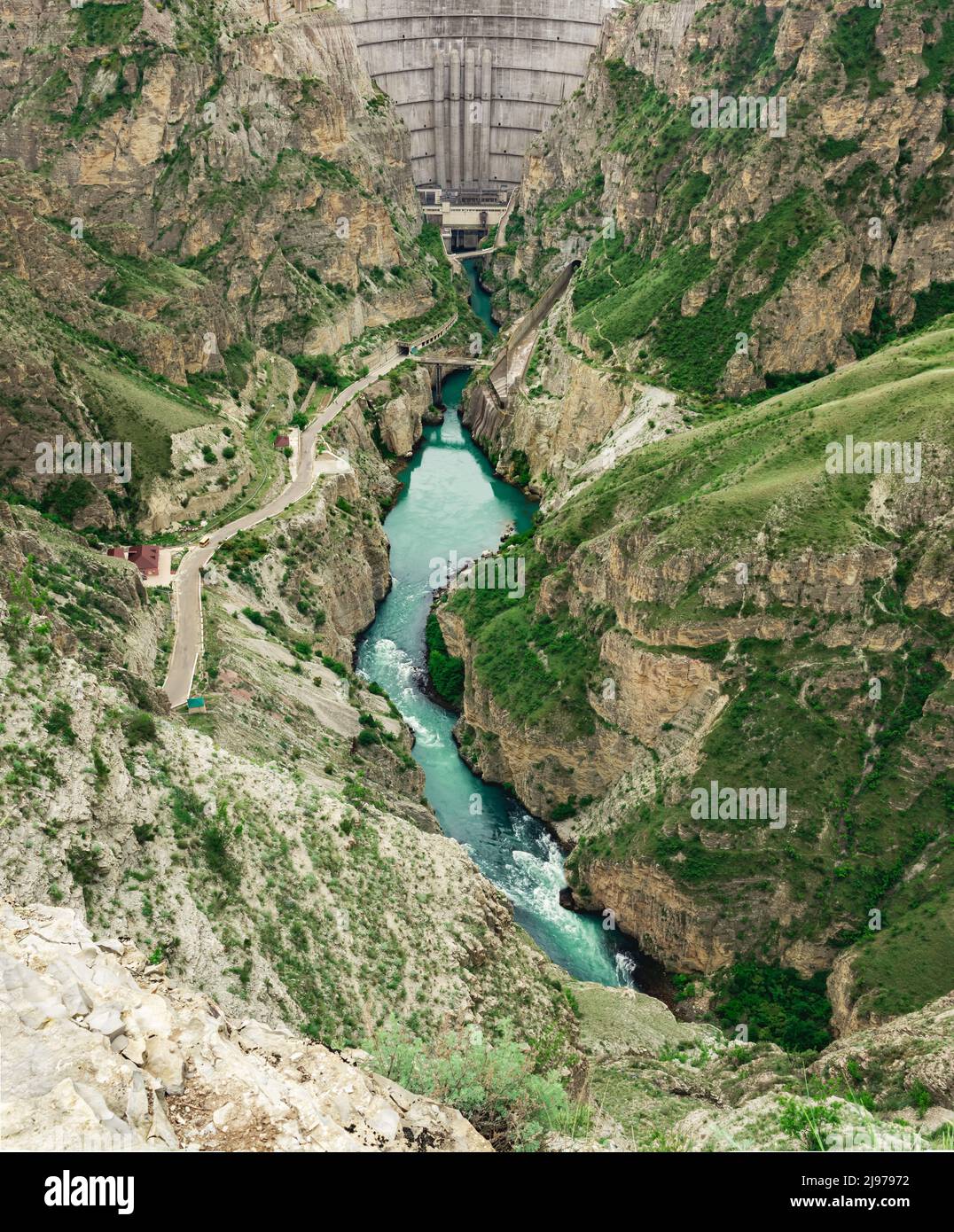 view of the lower part of the arch dam with a spillway and a mountain ...