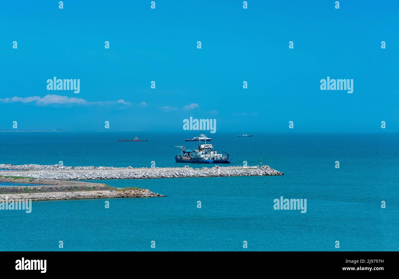 sea vessels and tugboats on the roadstead of the port against the ...