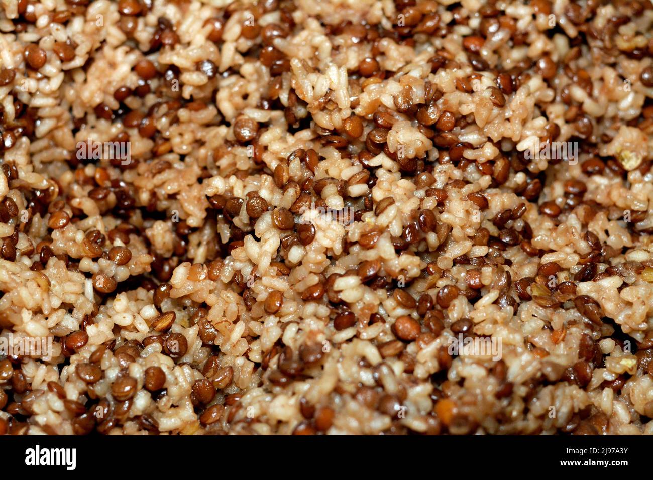 white rice and brown lentils cooked on hot steamed water vapor which is ...