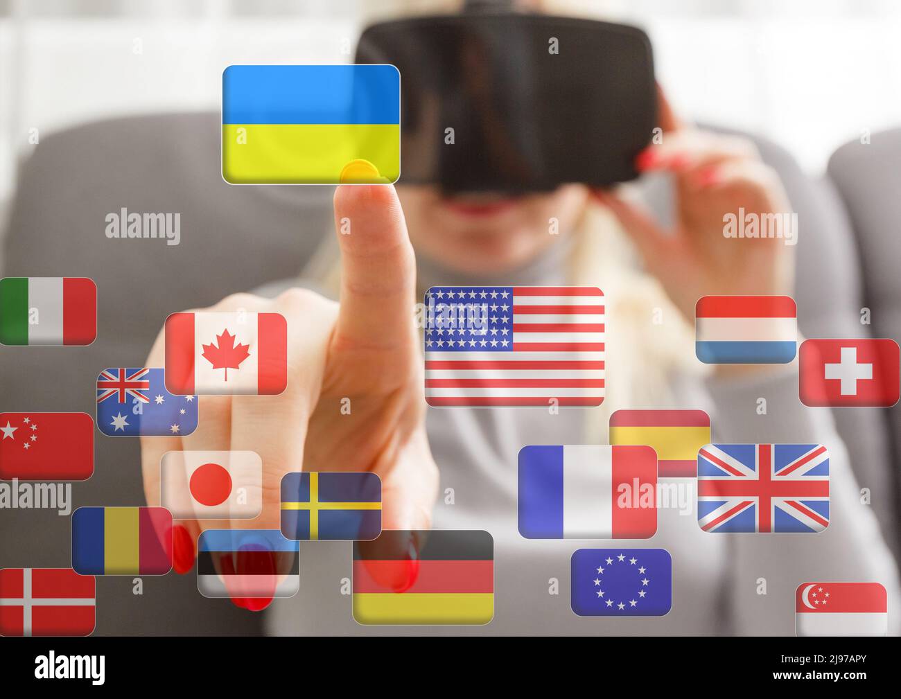 Hand pushing on a touch screen interface, choosing Ukraine. flags of ...