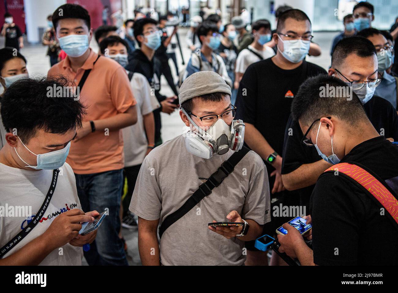Wuhan, China. 21st May, 2022. People wearing masks wait in line at the ...