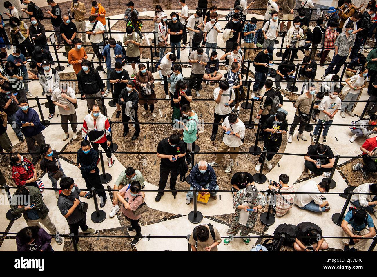 Wuhan, China. 21st May, 2022. People wearing masks wait in line at the ...