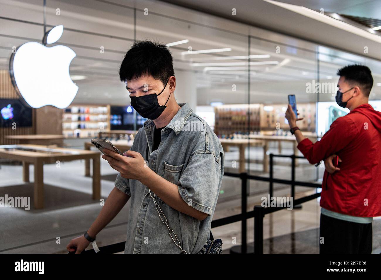 Wuhan, China. 21st May, 2022. People wearing masks wait in line ...