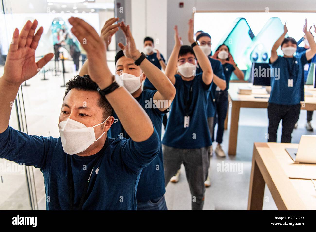 Wuhan, China. 21st May, 2022. Apple staff wearing masks welcome ...