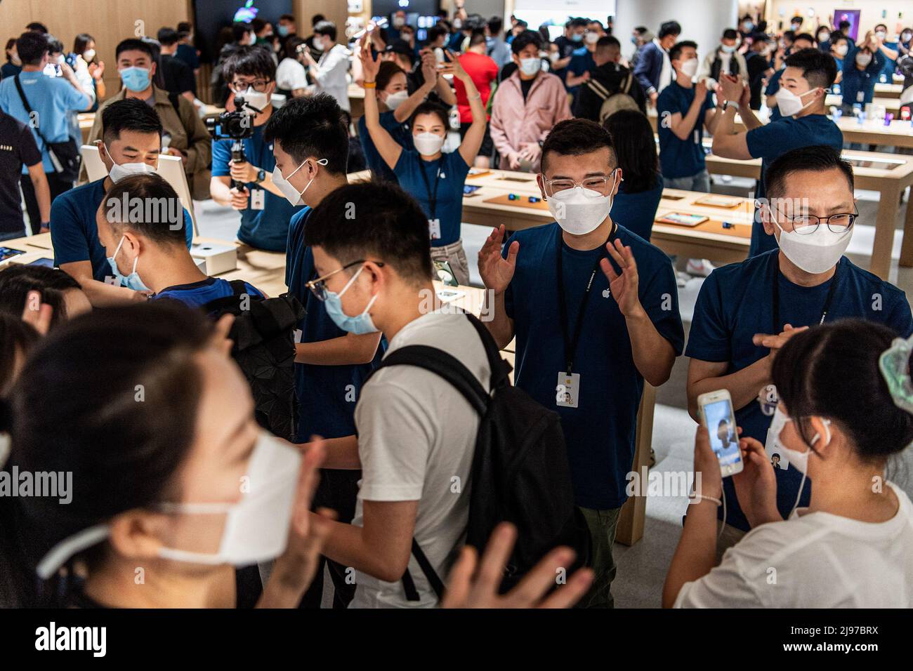 Wuhan, China. 21st May, 2022. Apple staff welcome customers as they ...