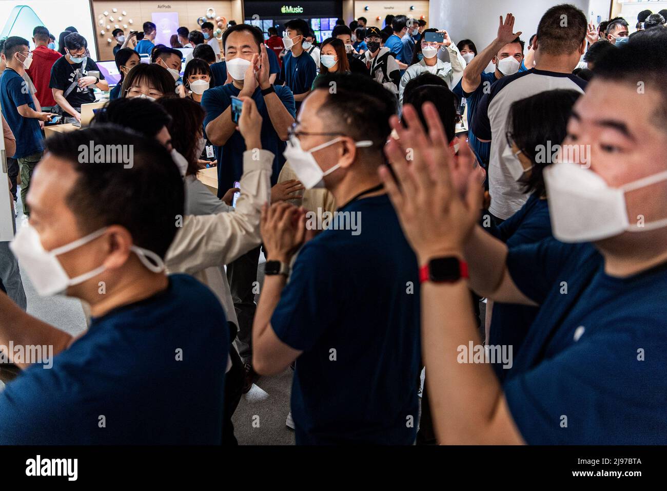 Wuhan, China. 21st May, 2022. Apple staff wearing masks welcome ...