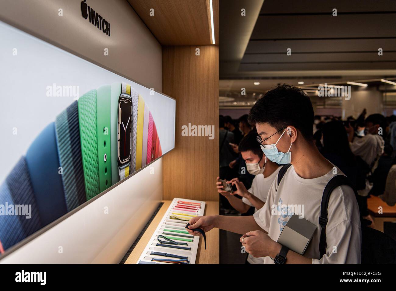 A Chinese customer wearing a mask tries Apple Watch at the official ...