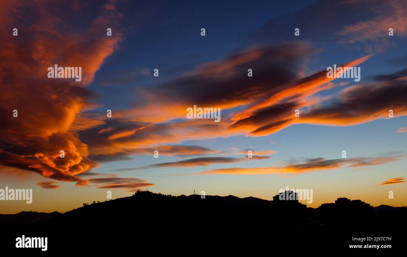 beuatiful orange color clouds in blue sky with silhoutte shadow hill ...