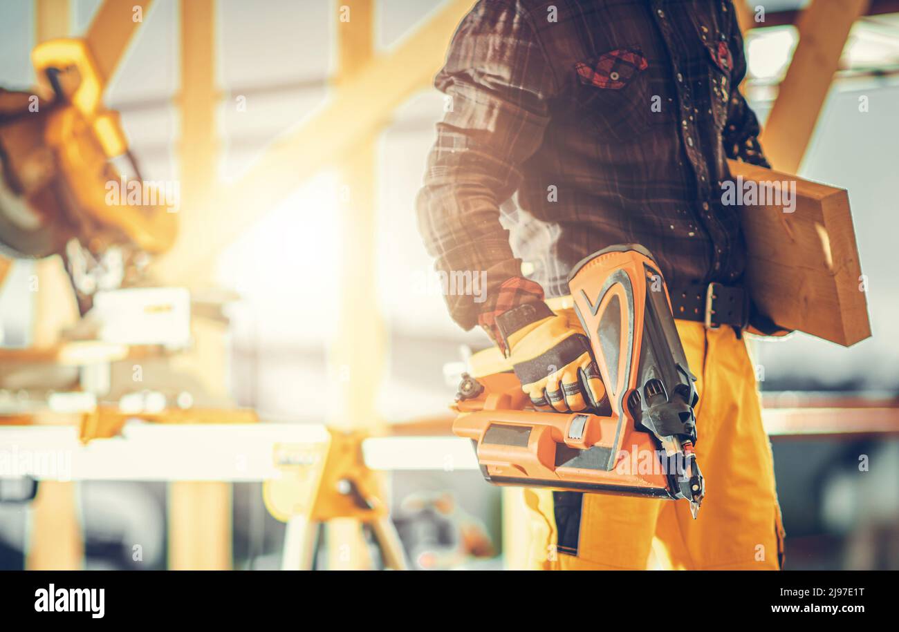 Construction Contractor with a Nail Gun in His Hand Working on a New ...
