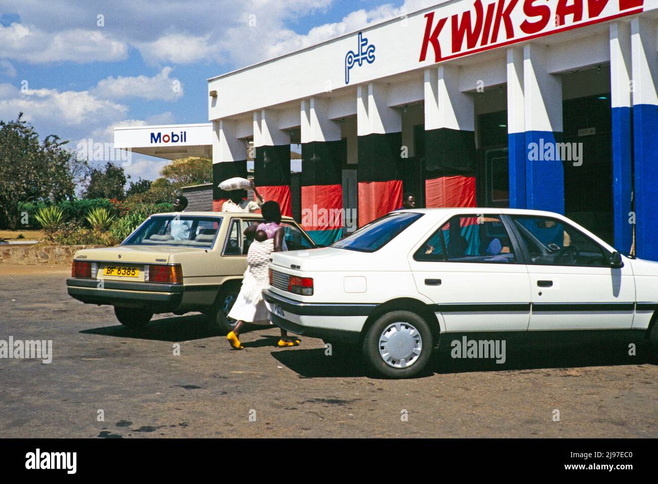 Mobil petrol station amd cars parked outside Kwiksave PTC shop store ...