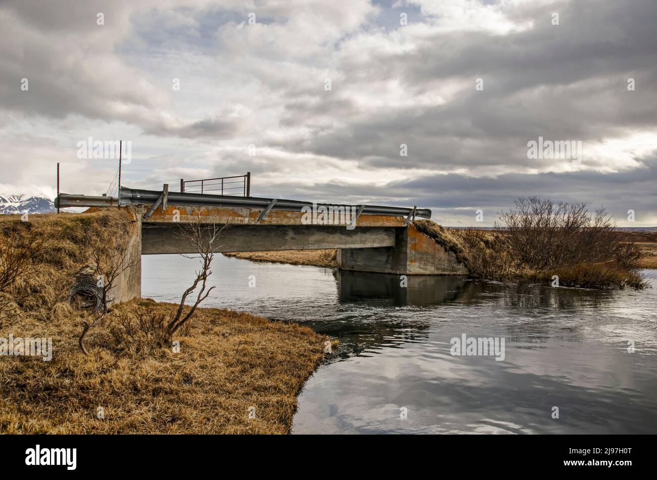 Simple concrete bridge across a stream coming from the mountains and ...