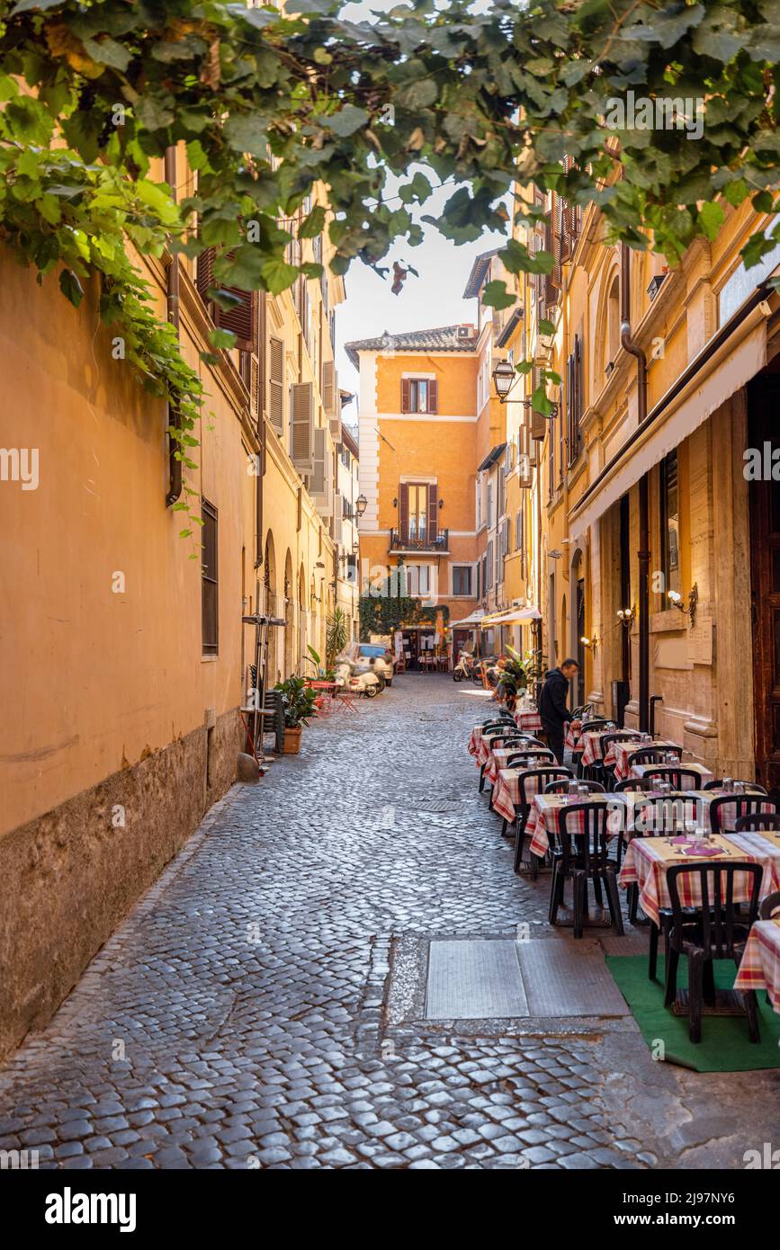 Narrow street with cafe and small shops in Rome Stock Photo - Alamy
