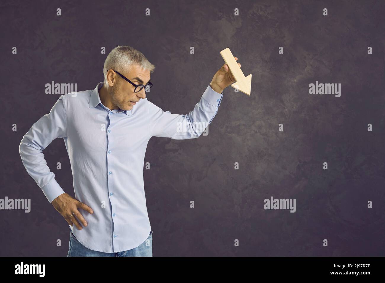 Unhappy man point down with paper arrow Stock Photo - Alamy