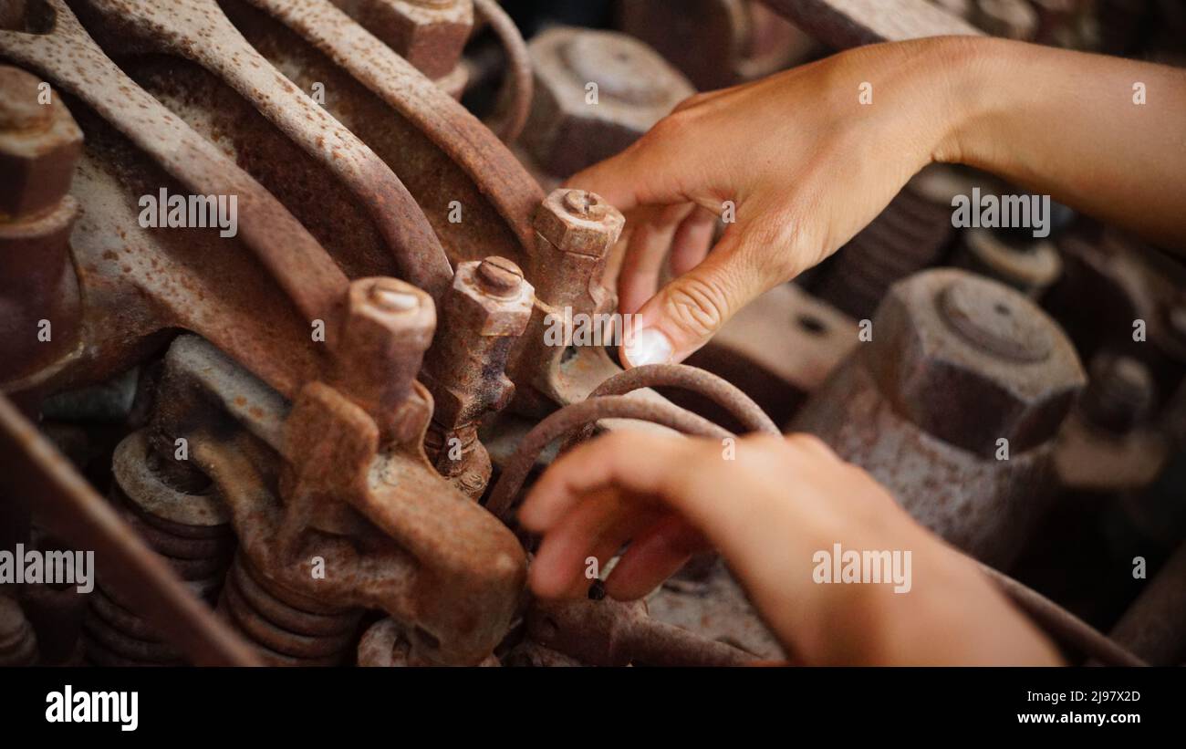 Women's hands touch the old rusty mechanism Stock Photo - Alamy