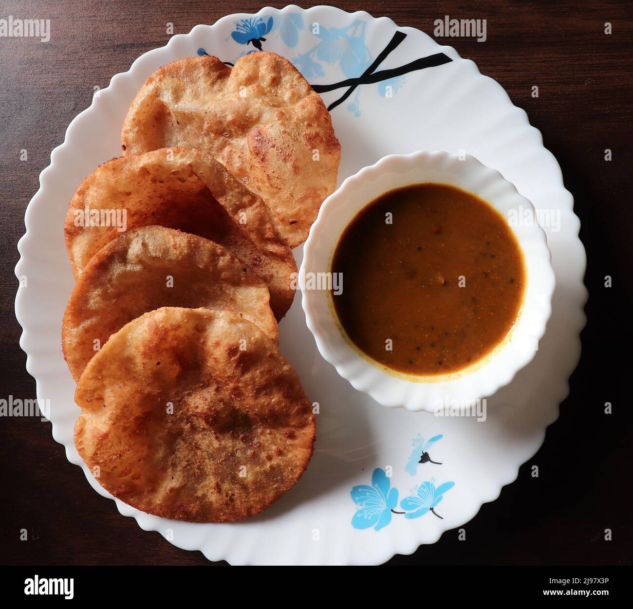 Fried Poori / Indian dish and Bengal gram curry in a ceramic plate ...
