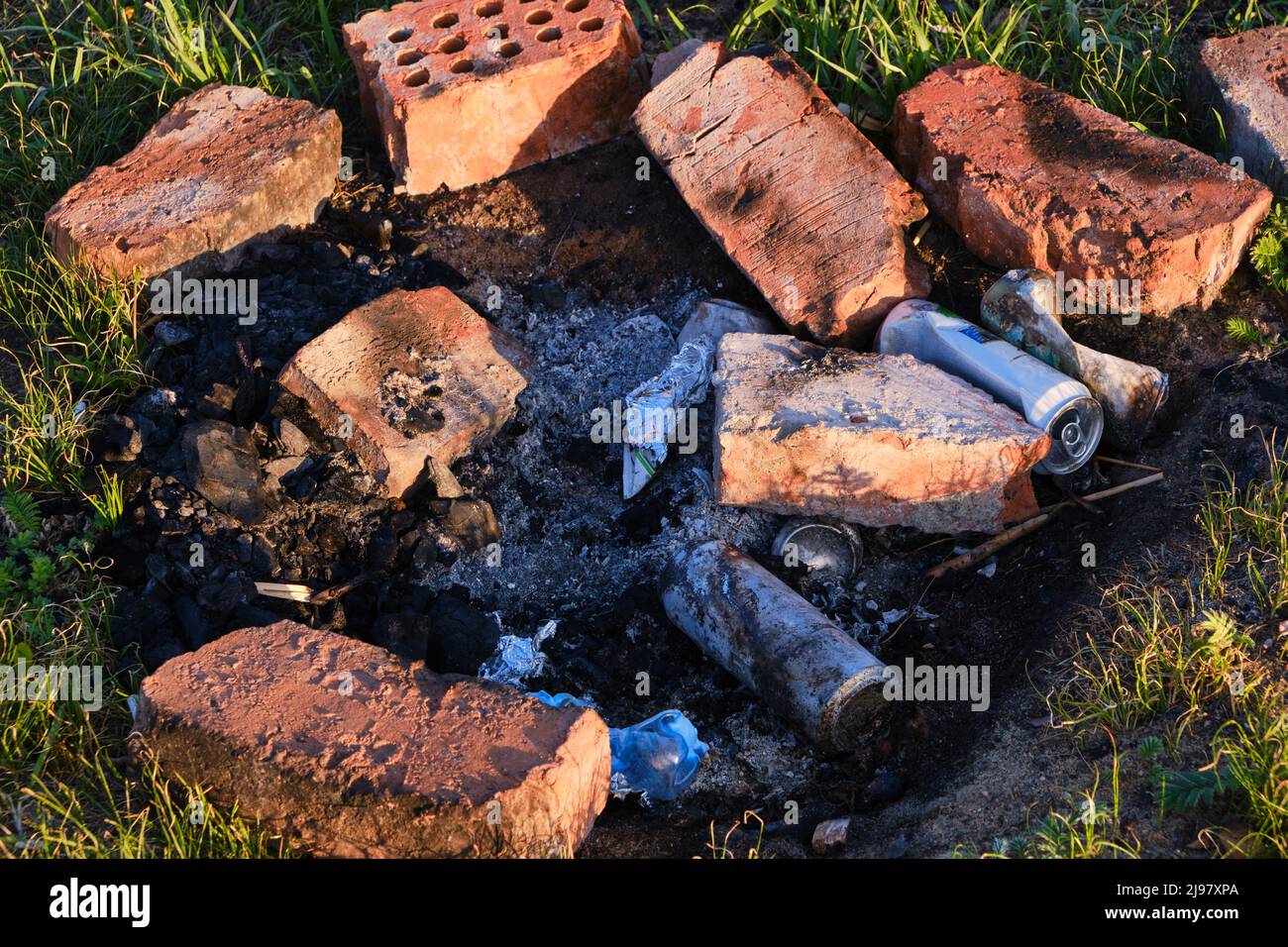 Remains extinguished bonfire and abandoned garbage, environmental ...