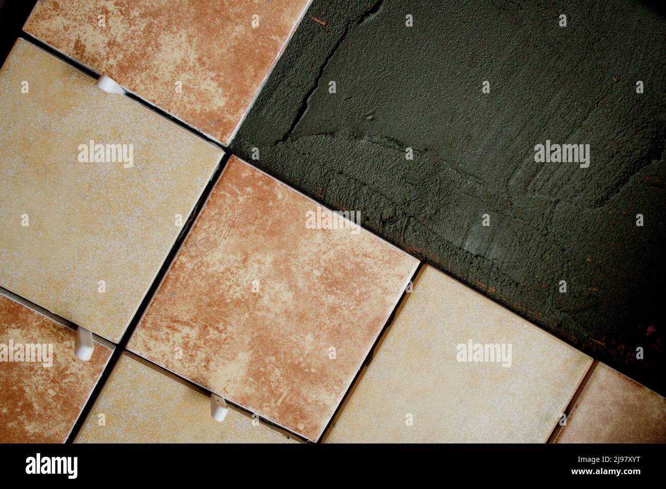 A section of freshly laid brown and cream tiles on the wall with ...