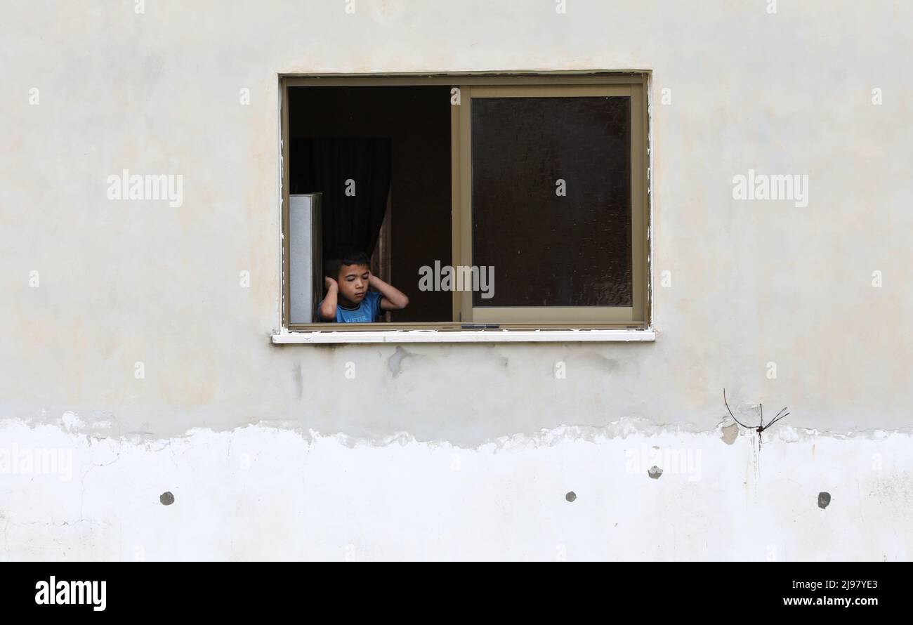 Jenin. 21st May, 2022. A boy covers his ears with hands as he looks ...