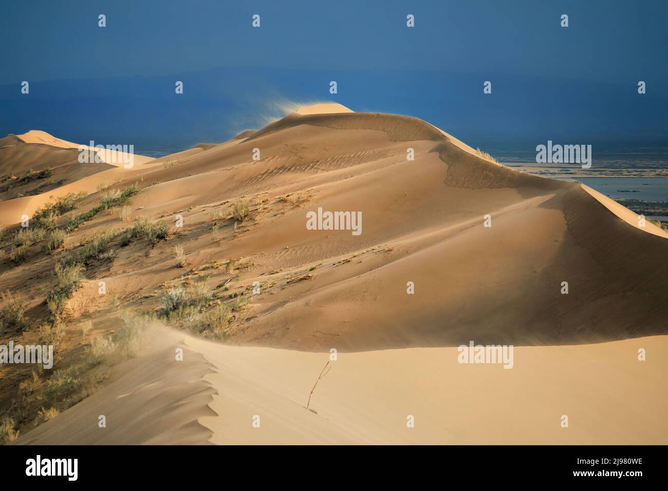 Sunset landscape of Singing Sand Dunes barkhan and ili river in famous ...