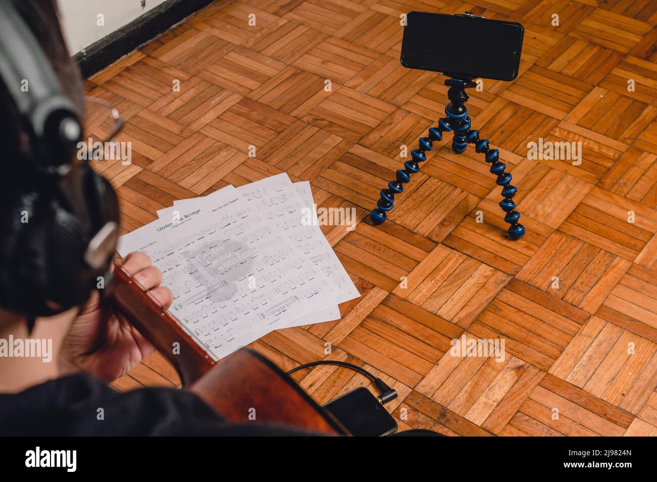 rear view caucasian man with headphones, sitting on the floor studying ...