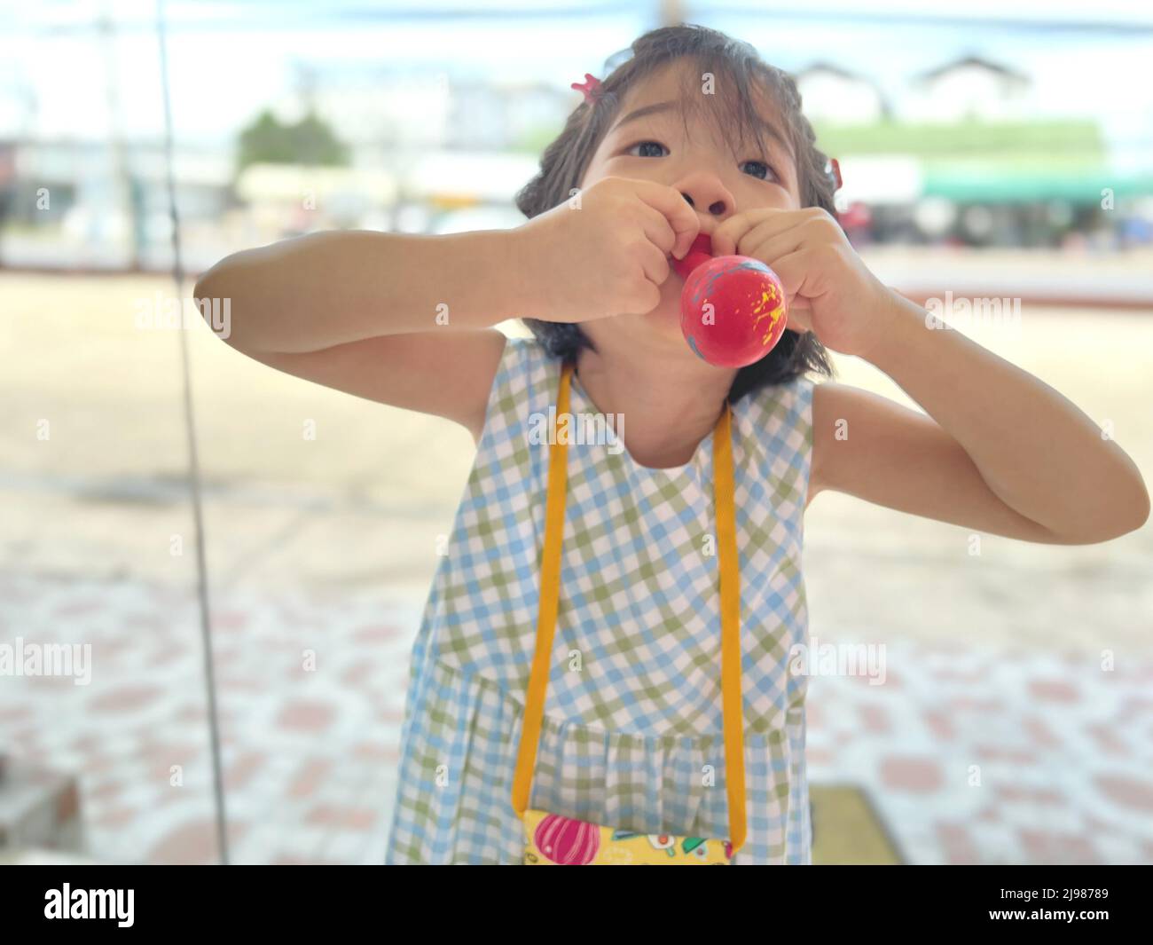 cute little girl tries to inflate a balloon Stock Photo - Alamy