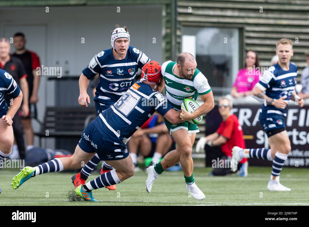 Jordan Burns of Ealing Trailfinders is tackled by Ryan Burrows, captain ...