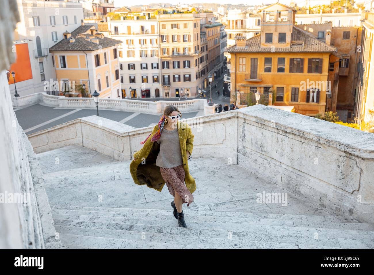 Woman running on famous Spanish steps on background of old town in Rome ...