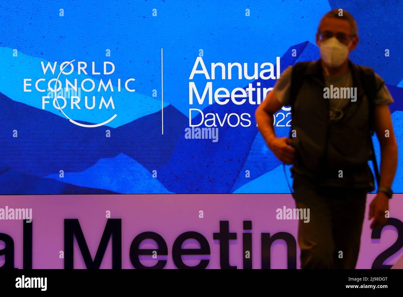 Davos, Switzerland. 21st May, 2022. A man walks past the sign for the ...