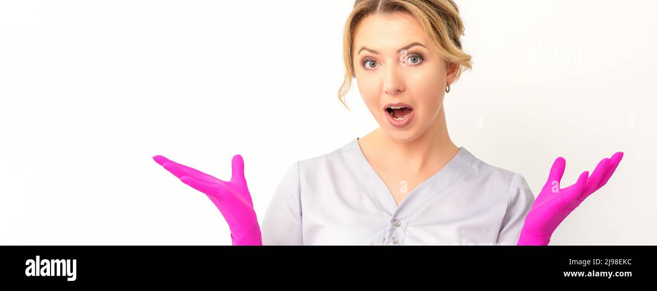 Body language. Young surprised Caucasian woman doctor wearing gloves ...