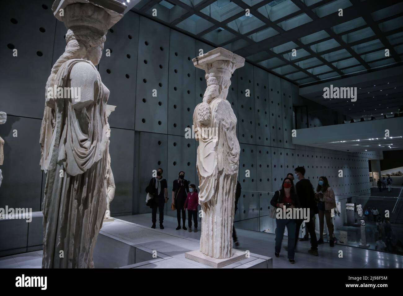 Visitors pass by the Caryatid statues in the Acropolis Museum in Athens ...