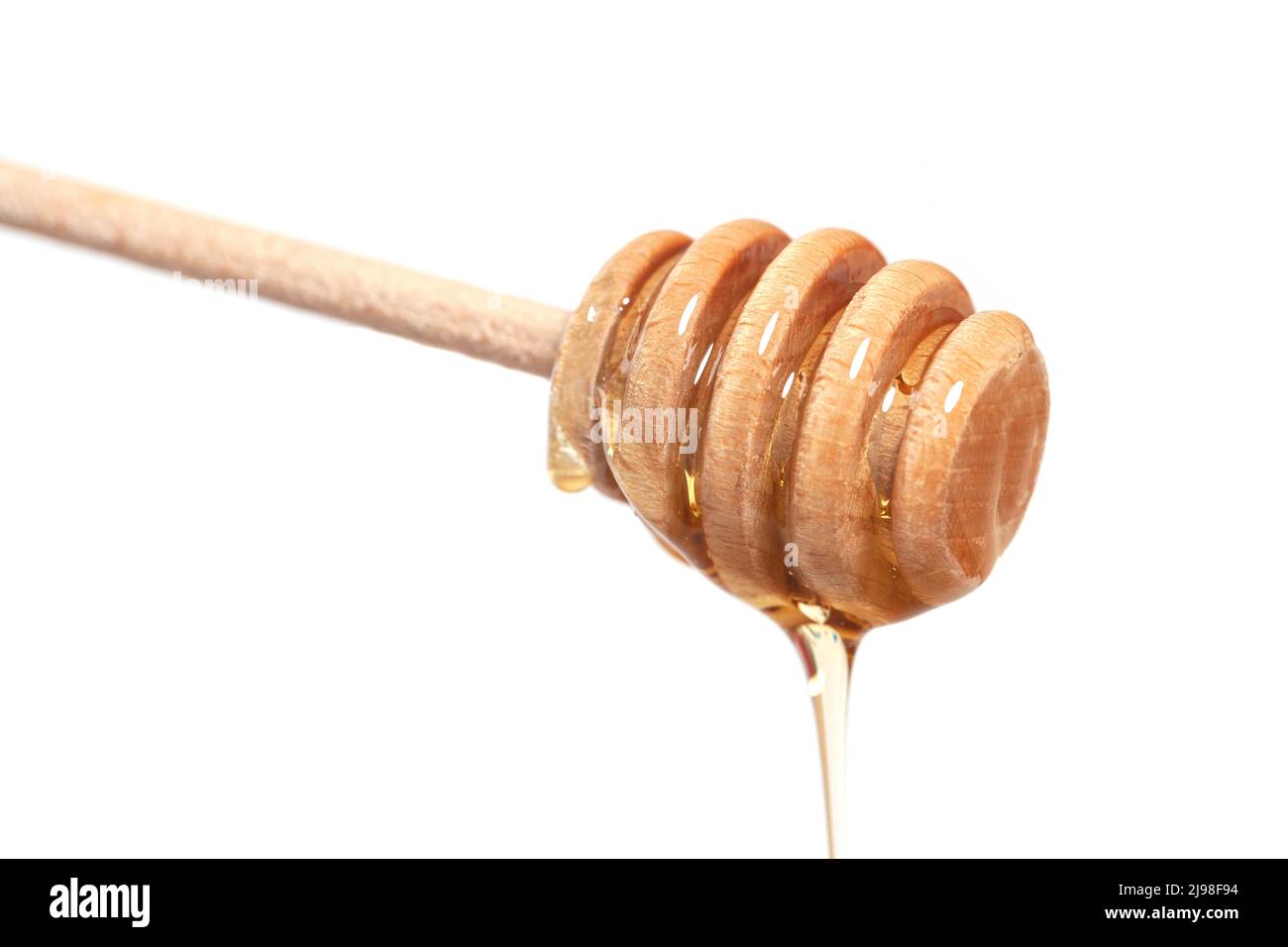 Wooden dipper with honey falling down isolated on a white background ...