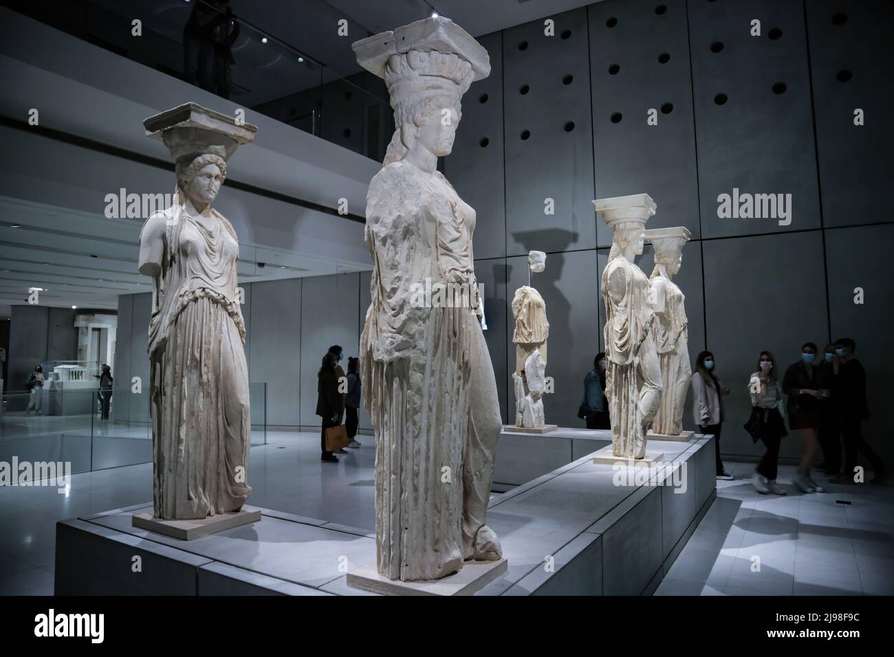Visitors pass by the Caryatid statues in the Acropolis Museum in Athens ...