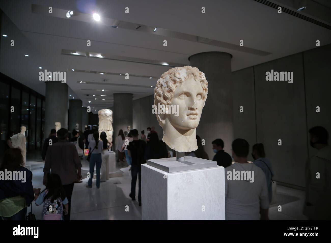Visitors pass by the head of a statue of Alexander the Great in the ...