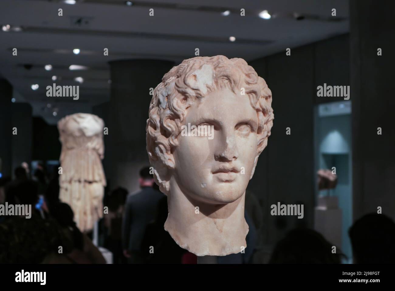 Visitors pass by the head of a statue of Alexander the Great in the ...