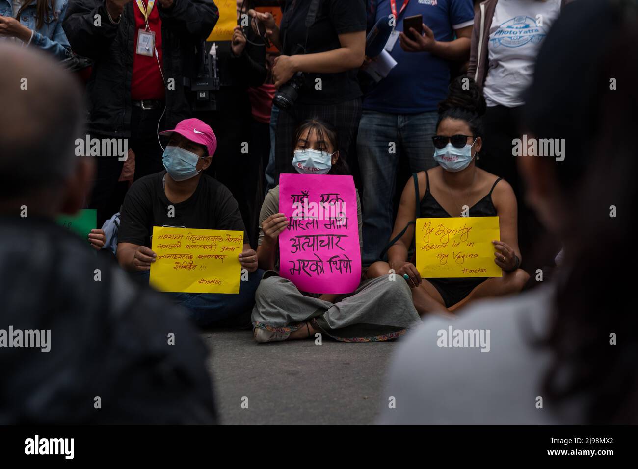 Youths sit-in while holding placards during the protest. Hundreds of ...