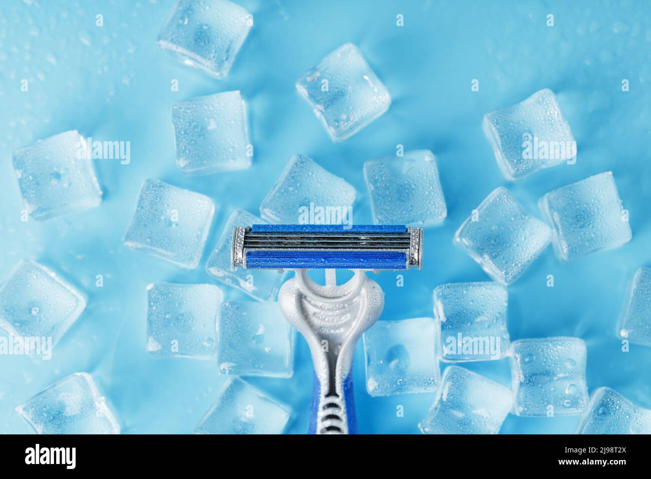 Shaving machine on a blue background with ice cubes. The concept of ...