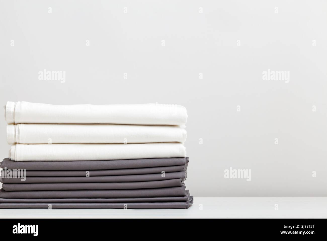 A stack of gray and white bed linens, sheets on the table Stock Photo ...
