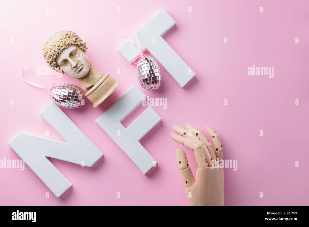 NFT (Non-Fungible token) and artificial arm on a pink background ...