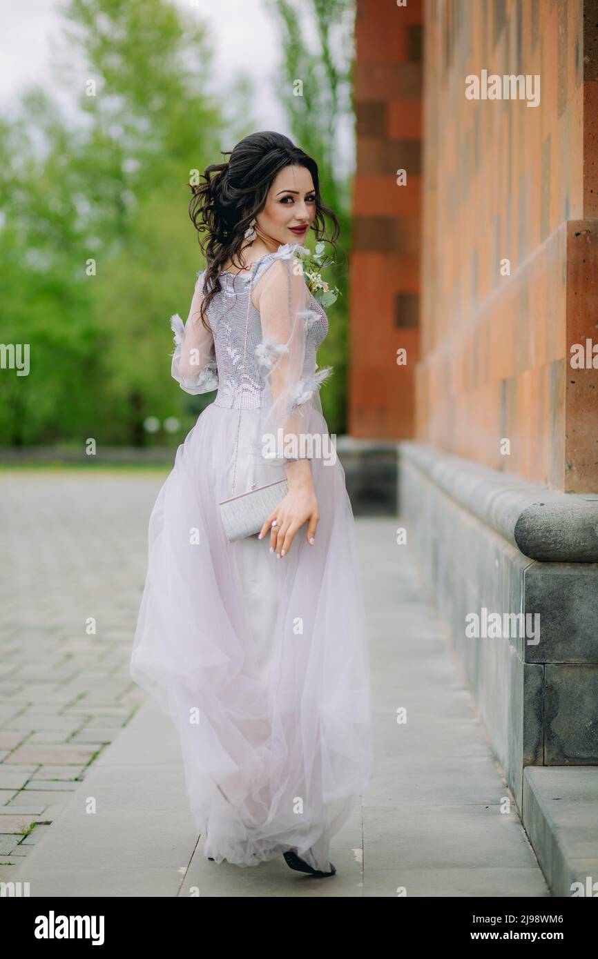 Back view of adorable bridesmaid walking and looking back at camera ...
