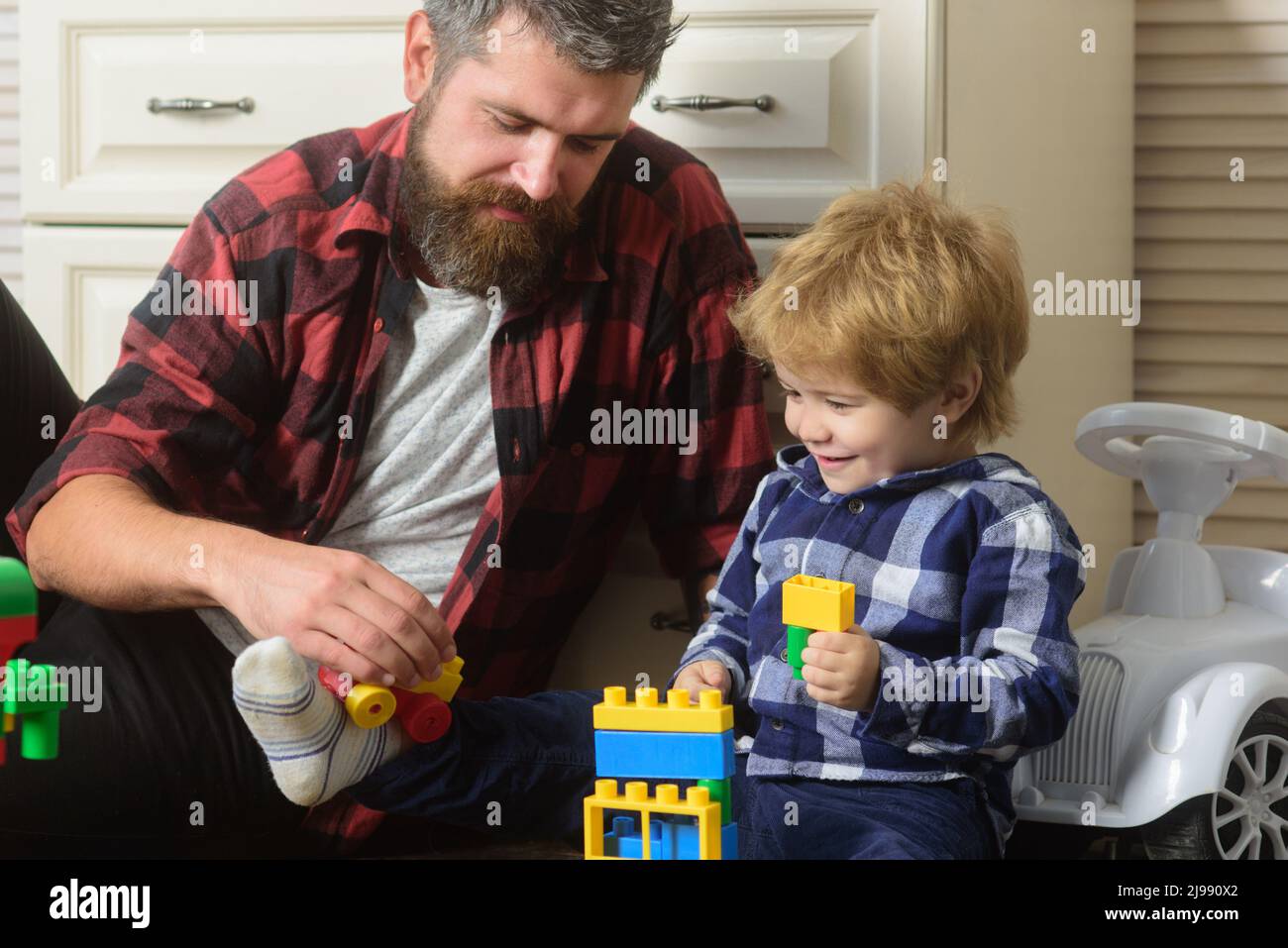 Father and son create toys from bricks. Father and son family time ...