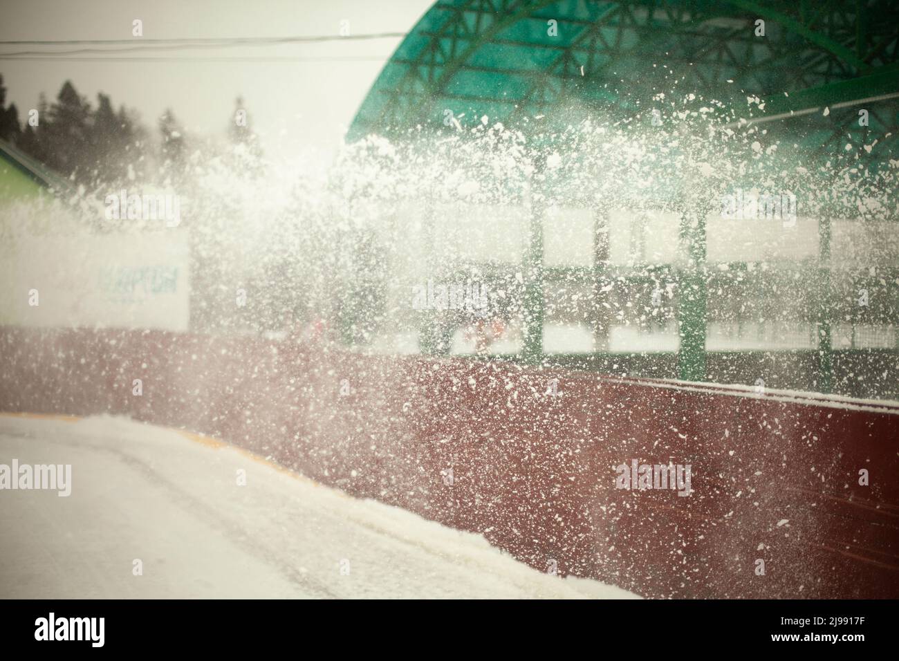 Snow on skating rink. Snow clearing. Small snowflakes fly overboard ...