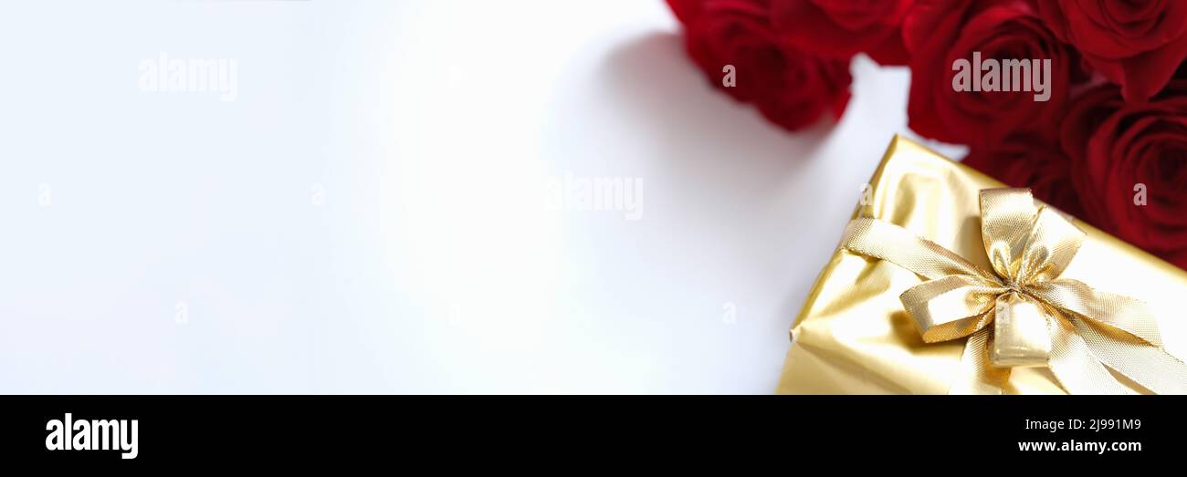 Beautifully wrapped gift in gold paper with ribbon Stock Photo - Alamy