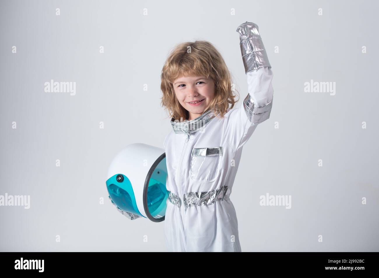 Cute smiling little boy spaceman child in space suit holding helmet ...