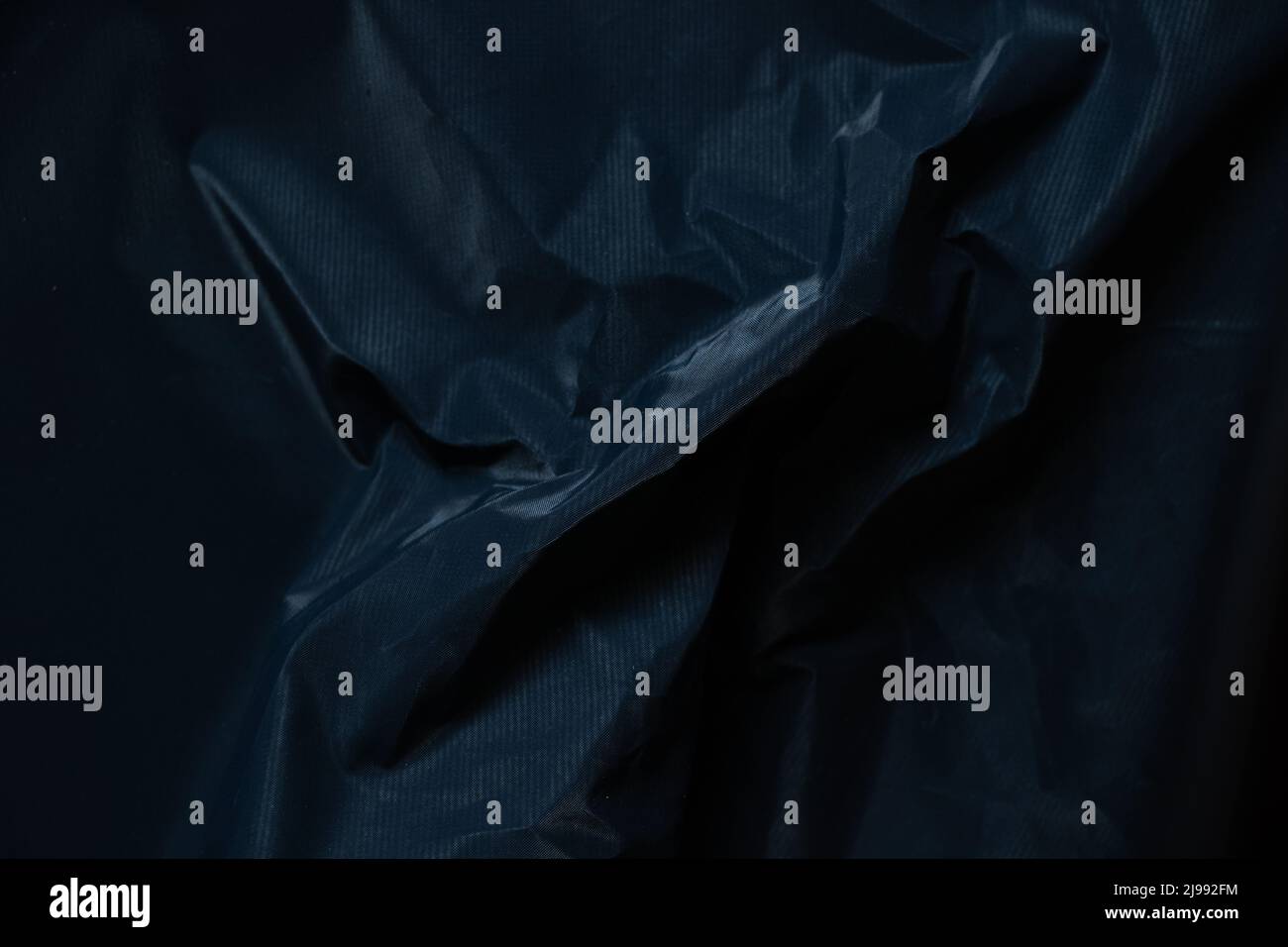 dark blue wrinkled fabric, blue background closeup, rough background ...