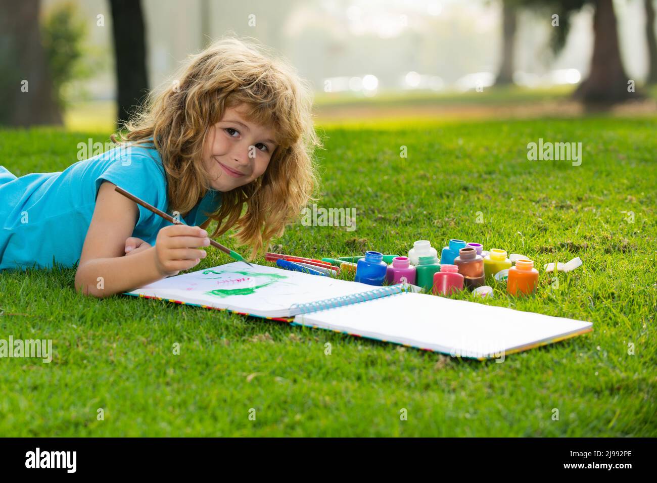Kids painting in spring nature. Child boy enjoying art and craft ...