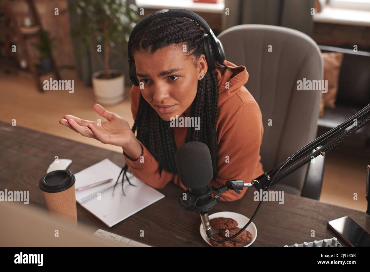 High angle view portrait of young female influencer wearing headphones ...