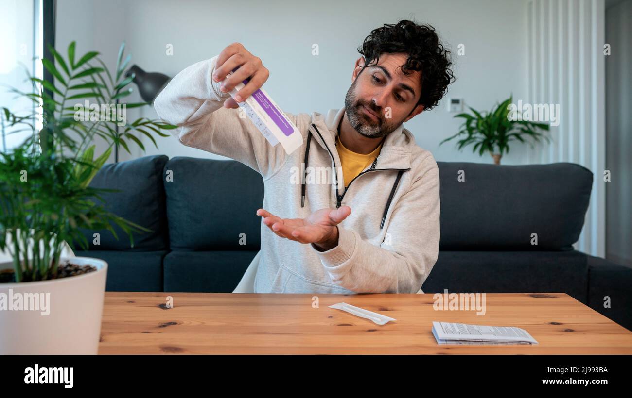 Caucasian man opening and unpacking a box of rapid test for covid-19 at ...
