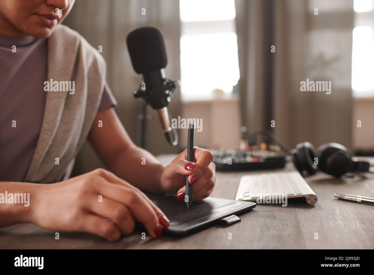 Medium close-up shot of unrecognizable female digital artist sitting at ...